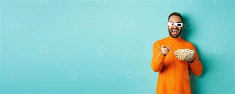 Man Watching Comedy In 3d Glasses Eating Popcorn Laughing And Pointing At Camera Tv Screen