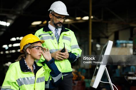 두 명의 유지 보수 엔지니어가 노트북 을 통해 릴레이 보호 시스템을 검사합니다 그들은 중공업 제조 공장에서 일합니다 공장 산업