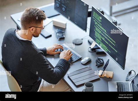 high angle view at software developer writing code while using computer