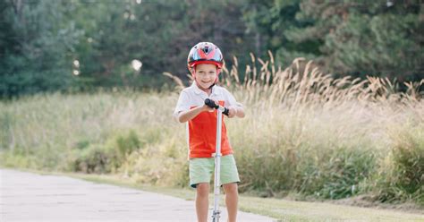 여름날 공원에서 스쿠터를 타는 헬멧을 쓴 행복한 백인 소년 계절에 따라 야외 어린이 활동 스포츠 건강한 어린 시절의 생활 방식 사진 Unsplash의 캐나다 이미지