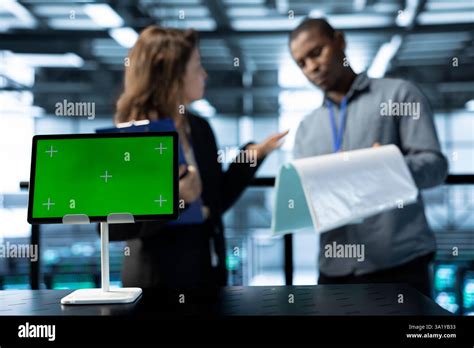 Mockup Tablet Used By Data Center Engineers In Blurry Background Reviewing Equipment Diagnostics