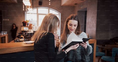 카페에 앉아 커피를 마시며 좋은 책을 읽고 있는 두 젊은 여성 커피 브레이크에 학생들 교육 라이프 스타일 개념 사진 Unsplash의 우크라이나 이미지