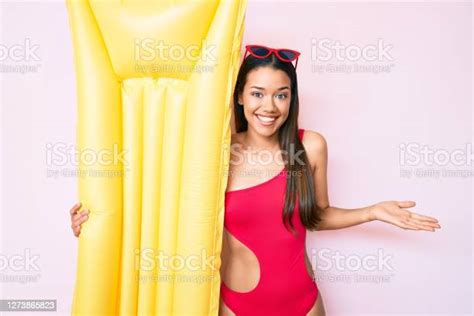 수영복을 입고 여름 매트를 들고 있는 젊은 아름다운 라틴 소녀 행복한 미소와 승자 표정으로 성취를 축하합니다 공기 주입에 대한 스톡 사진 및 기타 이미지 Istock