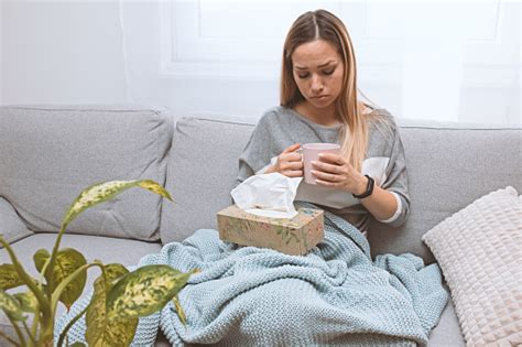 아픈 여자는 담요 아래에 앉아 코를 불고 계절 감염 독감 침대에 누워 알레르기가있는 아픈 여성 아픈 여자는 고열과 독감 휴식과 침대에 누워 담요로 덮여 건강관리와 의술에