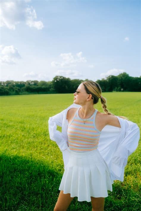 Portrait Of Young Attractive Caucasian Woman Fashion Model Posing On A Green Countryside Field