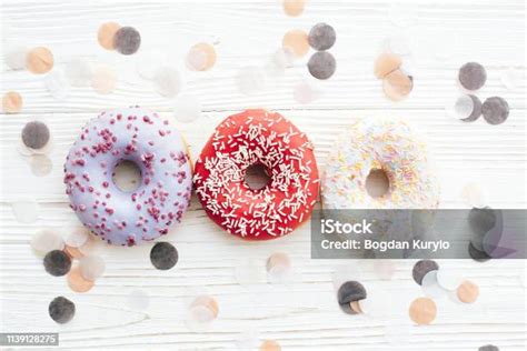 색종이 평면 누워 세련 된 흰색 테이블에 뿌리와 함께 맛 있는 다채로운 도넛 파티 개념입니다 다이어트 없음 웨딩 리셉션에서 캔디 바 퍼플 핑크 화이트 도너츠 도넛에 대한