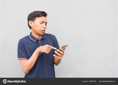 Indonesian Guy Pointing His Index Finger Phone Disgusted Facial Expression Stock Photo