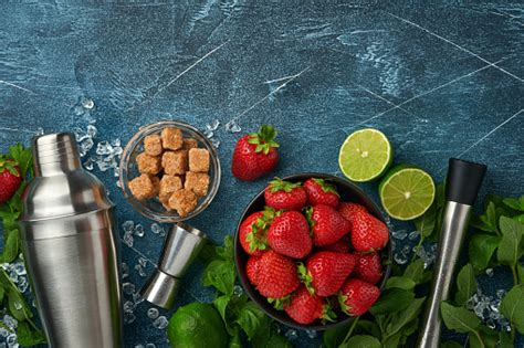 레모네이드 주입된 해독물 또는 칵테일을 만들기 위한 신선한 재료 진한 파란색 돌 배경에 딸기 라임 민트 바질 지팡이 설탕 얼음