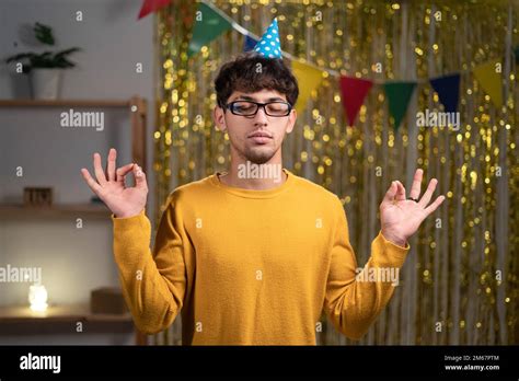 Concentrated Relaxed Man Standing With Closed Eyes In Party Hat Having