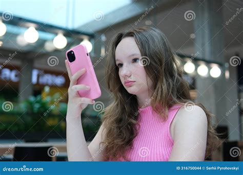 A Cute Girl 15 18 Years Old Sitting At A Table Takes A Selfie Online