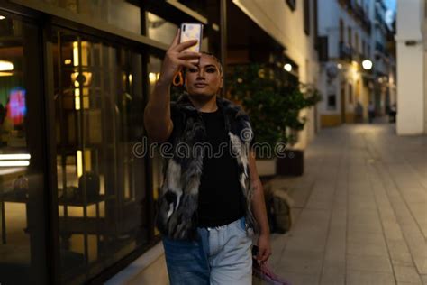 An Adult Non Binary Gender While Shopping With Bags Takes A Selfie
