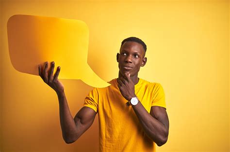 질문에 대해 생각 하는 고립 된 노란색 배경 심각한 얼굴 위에 서 연설 거품을 들고 젊은 아프리카 계 미국인 남자 매우 혼란