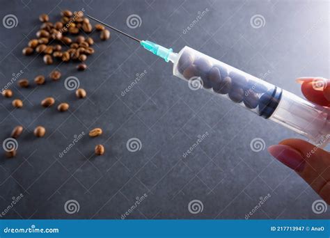 Grains Of Coffee And An Injection Syringe In Female Hands Caffeine Addiction Concept Stock