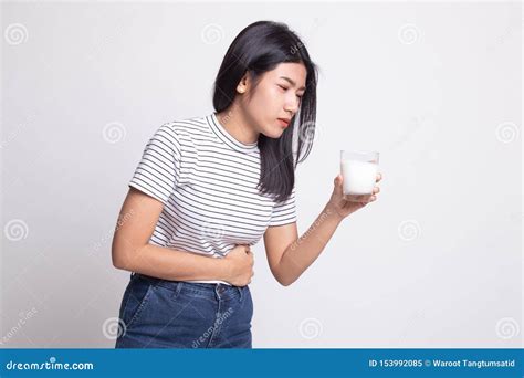 Den Asiatiska Kvinnan Som Dricker Ett Exponeringsglas Av Mj Lkar F Nget Magknip Fotografering