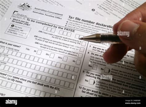A Pen Hold By The Fingers Of Somebody Ready To Fill An Australian Tax File Number Declaration