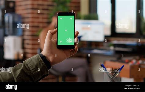 Businessman Analyzing Smartphone With Greenscreen Display In Startup