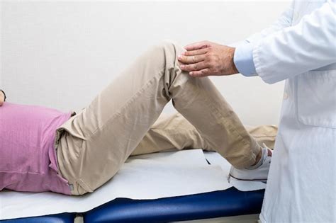 Premium Photo Doctor Examining Patients Knee In Clinic