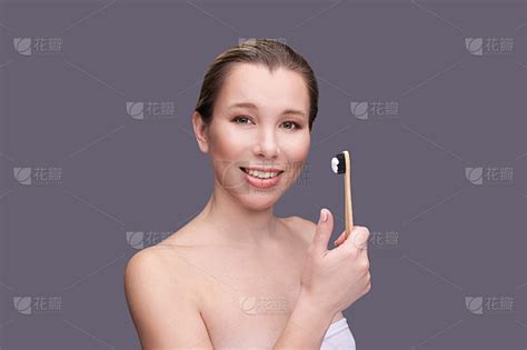 女孩拿着带牙膏的牙刷。口腔回家的习惯