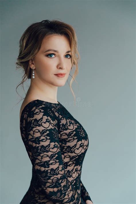 Beautiful Young Blonde Woman With Blue Eyes In A Black Guipure Dress