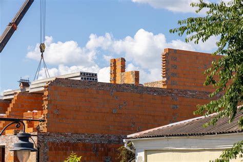 Workers Are Assembling A Brick Wall At A Construction Site With A