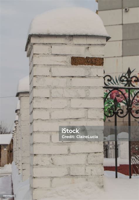 Pilar Bata Dengan Plester Putih Berdiri Berturutturut Membentuk Pagar Dengan Batang Logam Di