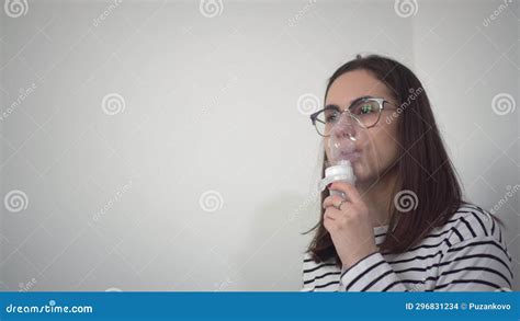 A Young Woman Breathes Through An Inhaler Mask Closeup A Girl In