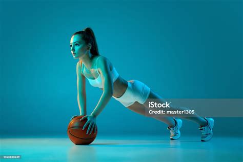 흰색 운동복 훈련을 받은 어린 스포티한 소녀 네온 불빛의 파란색 스튜디오 배경 위에 격리된 판자 위치에 있는 공에 서 여자만에 대한 스톡 사진 및 기타 이미지 Istock