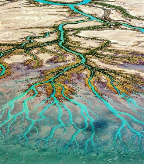 An Aerial View Of Water And Land With Blue Yellow And Green Streambeds