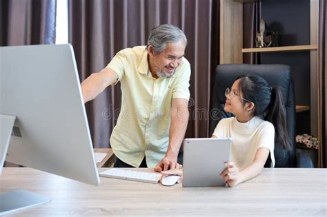 Young Asian Schoolgirl Is Doing Her Class Homework Assignment At Home With Advice From