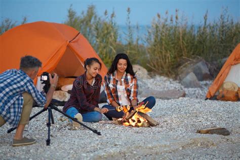 Friends Capturing Campfire Memories At Beachside Campsite Stock Image