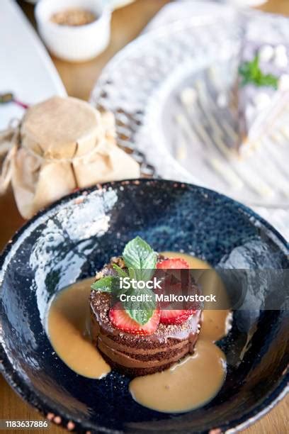 딸기와 민트 잎으로 장식 된 캐러멜 초콜릿 스폰지 케이크 카페에서 아침 식사 모닝 커피 카푸치노와 테이블에 디저트를 많이 0명에 대한 스톡 사진 및 기타 이미지 Istock