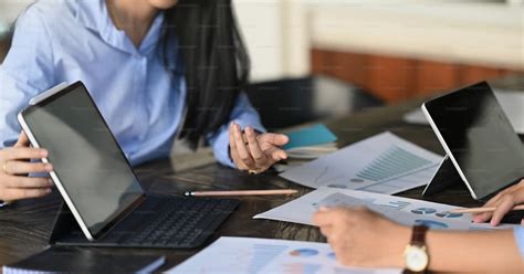 비즈니스 개발 팀이 컴퓨터 노트북 태블릿 및 문서 정보를 가지고 현대적인 회의 테이블에서 토론대화회의하는 잘린 이미지 사진 Unsplash의 사무실 이미지