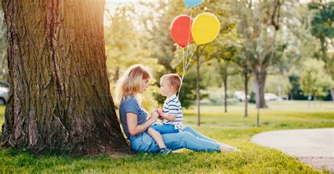 젊은 백인 어머니와 소년 유아 아들은 공원에서 푸른 잔디에 함께 앉아 있습니다 가족 엄마와 아이는 여름날 야외에서 의사 소통을합니다 행복 한 정통 가족 어린 시절 생활
