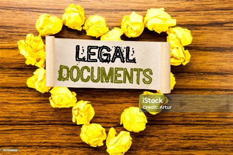 단어 법률 문서를 작성입니다 어두운 나무 배경에 스티커 메모 용지에 작성 된 계약 문서에 대 한 비즈니스 개념 노란 접힌된 종이 심장 의미 사랑 또는 숭배 개념에 대한 스톡