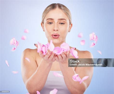 꽃잎 아름다움 그리고 스킨케어 웰빙 얼굴 광채를 위한 꽃을 가진 여성 고립된 파란색 배경과 스파 미학이 있는 스튜디오와 화장품을 위해 손에 꽃을 들고 있는 젊은 여성 모델