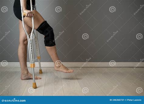 Women`s Legs With A Knee Brace And Crutches For Rehabilitation After