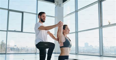 젊은 활동적인 여성이 체육관에서 훈련하는 동안 등을 위해 요가 운동을 하도록 돕는 전문 스포츠 트레이너 사진 Unsplash의 성인 이미지