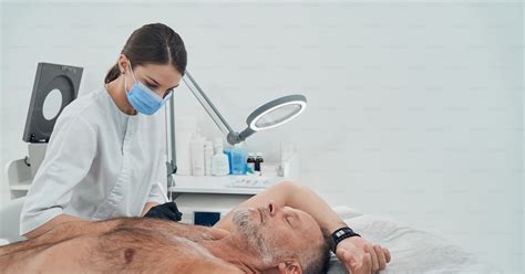 의료 마스크를 쓴 여성 의사가 눈을 감고 데이베드에 누워 있는 동안 시술 전에 고객 겨드랑이를 표시하는 여성 의사 사진 Unsplash의 건강한 라이프스타일 이미지