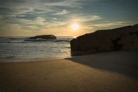 따뜻한가 10 월 카브 레 톤 프랑스에에서 푸른 황금 일몰 하늘에서 대서양에 파도 함께 아름 다운 모래 해변에서 아름 다운 바다 경치에 전쟁 요새의 실루엣 0명에 대한 스톡