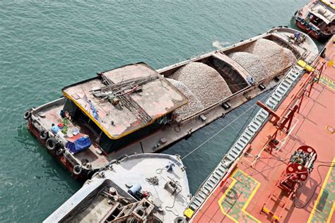 Loading Bulk Cargo Of Limestone From Barges Into A Bulk Carrier By Using Ship Cranes And Grabs