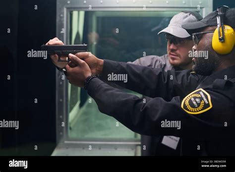 Instructor Teaching Safety Measures At Indoor Shooting Range Ensuring