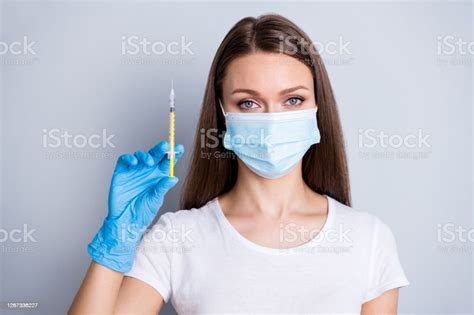 우리는 생명을 구합니다 여성 가족 의사 병원 검사의 클로즈업 사진은 주사기로 팔을 들어 올리고 환자를 보호하고 착용 착용하는 환자를 보호하여 얼굴 마스크 절연 회색 색