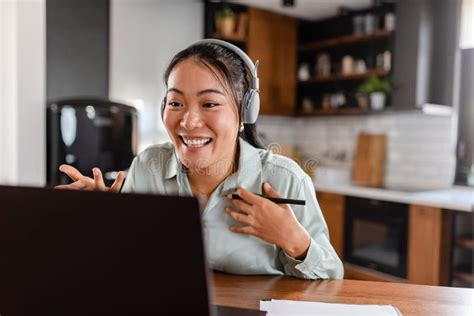 Young Asian Woman Working From Home Sitting In Front Of Laptop