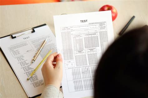 Female Student Hands Testing In Exercise And Hold Exam Paper Sheet With