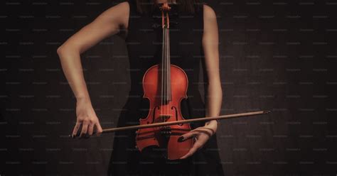 검은 배경에 바이올린을 연주하는 바이올리니스트 여자의 손 사진 Unsplash의 음악가 이미지