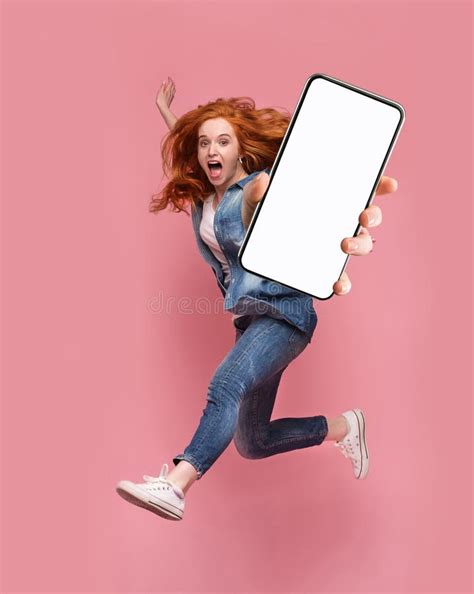 Excited Redhead Woman Having Fun Jumpingdemonstrating Mobile Phone