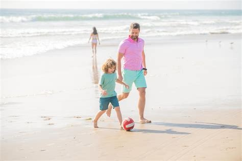 Premium Photo Father And Son Play Football On Beach Daddy With Kid Boy On Hot Summer Day