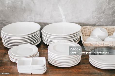 깨끗한 접시 및 기타 식기는 흰색 벽 배경에 고립 된 나무 선반 에 배치 된 나무 선반 템플릿으로 흰색 그릇과 접시를 복사 공간이있는 선반에 제품의 장식 된 인테리어 또는