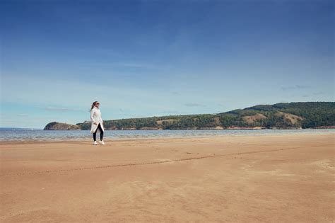하얀 코트에 빨간 머리카락을 가진 아름다운 여성이 추운 화창한 날에 모래 사장을 걷고 여성과 자연의 단결 40 44세에 대한
