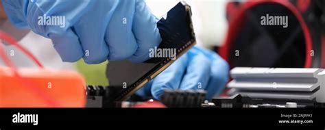 Repair Engineer Holds RAM Chip With Hands And Inserts RAM Of Computer Into Socket Of Computer